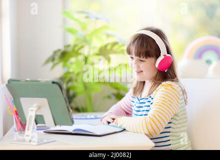 Online remote learning. School kids with computer having video ...