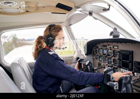 Side view of a female pilot in the cockpit of an airplane Stock Photo ...
