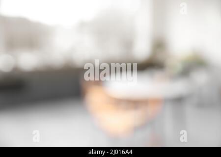 Blurred view of modern kitchen with counters and dining table Stock ...