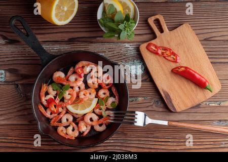 Shrimp pinchos tapas from Spain in pan, red pepper, lemon on wooden ...