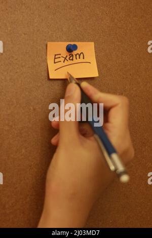 Exam text written on sticky note concept designed with woman hand Stock ...