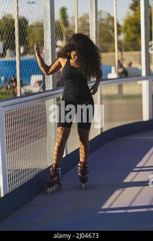 Vertical shot of a beautiful girl rolling in the park on a sunny day ...