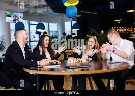 Businessmen are playing Jenga games. They sit in the office and play ...