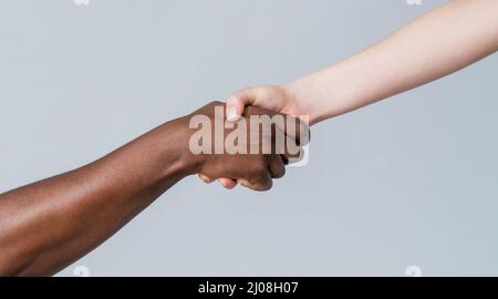 Helping hands, Rescue gesture. African and caucasian hands. Giving a ...