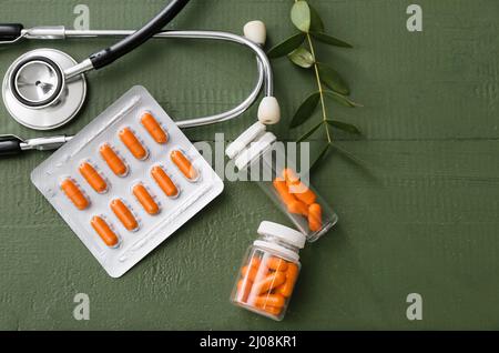 Blister pack with turmeric powder capsules and stethoscope on color ...