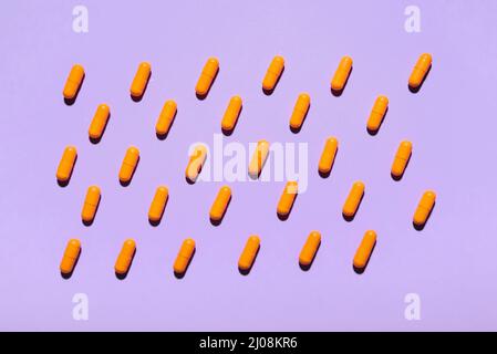 Turmeric powder capsules on purple background Stock Photo - Alamy
