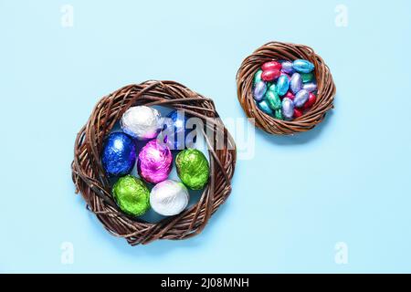 Nests with different Easter eggs on color background Stock Photo - Alamy