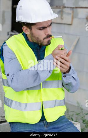 builder smoking cigarette on construction site Stock Photo - Alamy