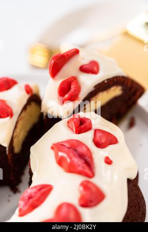 Slicing freshly baked red velvet bundt cake with chocolate lips and ...