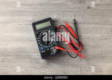 One black multimeter on gray textured background Stock Photo - Alamy