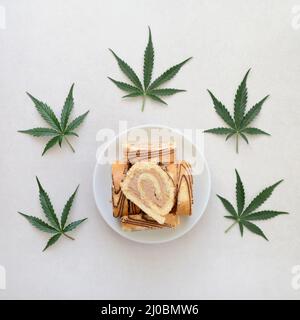 Sweet roll with marijuana oil on white plate. Cannabis kitchen. Layout ...