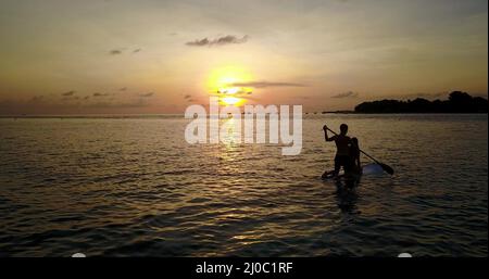 Male paddleboarding at sunset near Rasdhoo Island, the Maldives Stock ...