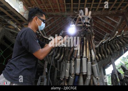 Surakarta, Indonesia. 18th Mar, 2022. A worker welds waste motorcycle ...