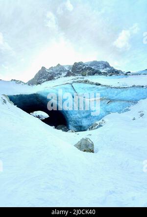 Closeup of a snowy cave with a mountain in the background Stock Photo ...