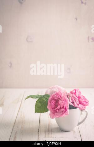 Pink tea roses on a white wooden background Stock Photo - Alamy