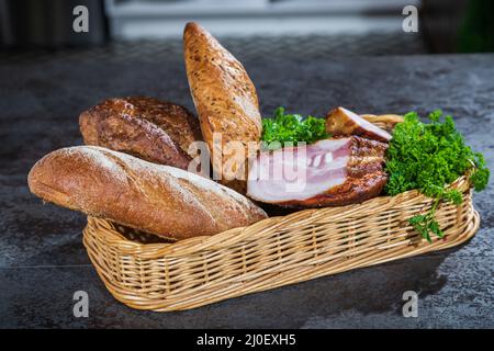 Bread and smoked meat in a braided basket on the table Stock Photo - Alamy