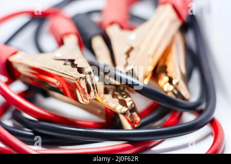 Car positive and negative, red and black, jump leads on car battery ...