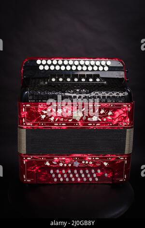 Russian folk instruments.Red bayan on a black background.Russian ...