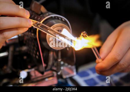 Glass sticks are heated in order to process them artistically Stock ...