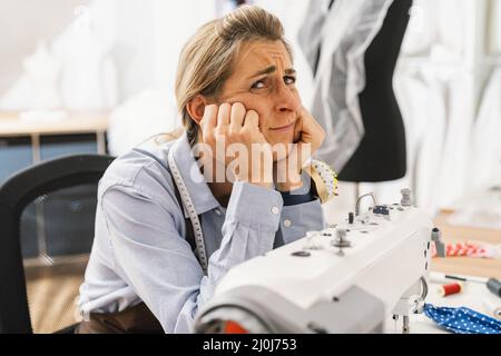stressed seamstress sitting at her workshop Stock Photo - Alamy