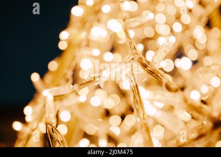 The festive garland glows with blurred bokeh and a flowerpot with a ...
