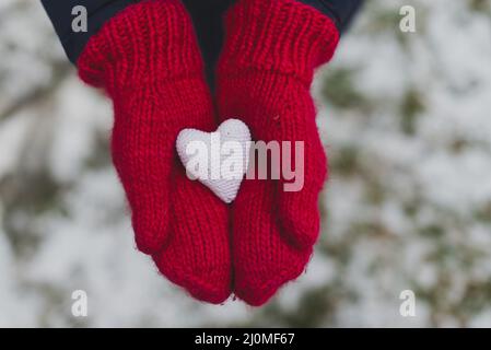 Gloved hands holding white heart Stock Photo - Alamy