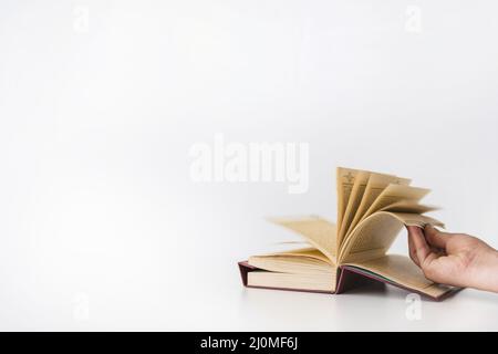 Hand turning pages book Stock Photo - Alamy