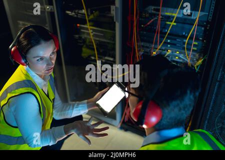 Diverse male and female engineer using digital tablet while inspecting ...