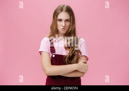 I mad on world. Unhappy hateful young arrogant girl in overalls with ...