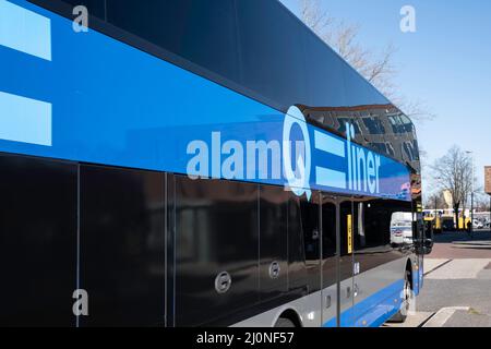 Side view of a blue Qliner bus at the station of the dutch village of ...