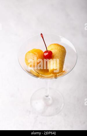 Neapolitan Rum baba (or baba au rum) in a martini glass with a cocktail ...