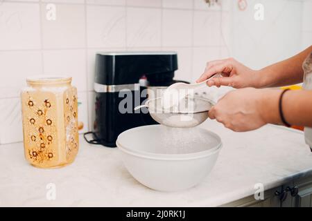 Pastry chef sift pours flour makes cake. Cooking and preparing dessert ...