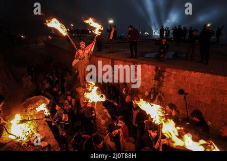 Akre, Iraq. 20th Mar, 2022. Iraqi Kurdish men hold fire torches as they ...