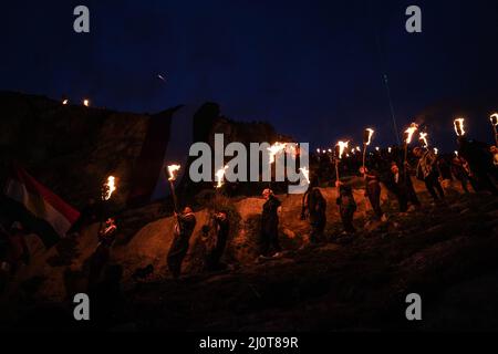 Akre, Iraq. 20th Mar, 2022. Iraqi Kurdish men hold fire torches as they ...