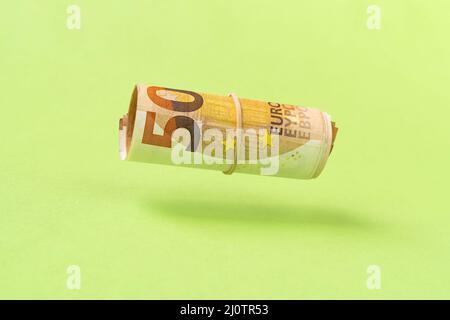 Roll of euro currency levitating over green background. Financial ...