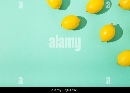 Yellow whole lemons on minimal blue background on bright sun light with ...