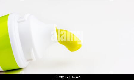 green toothpaste is squeezed out of a tube of toothpaste on a white ...