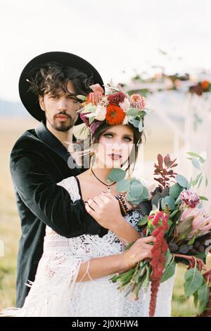 Bride hug groom from behind on the stone steps of a building. Bergamo ...