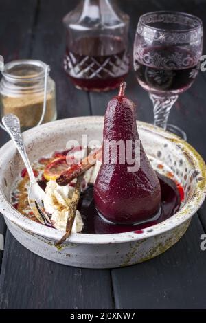 Traditional poarched pear in red wine sauce offered as close-up on a ...