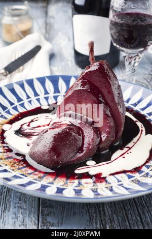 Traditional poarched pear in red wine sauce offered as close-up on a ...