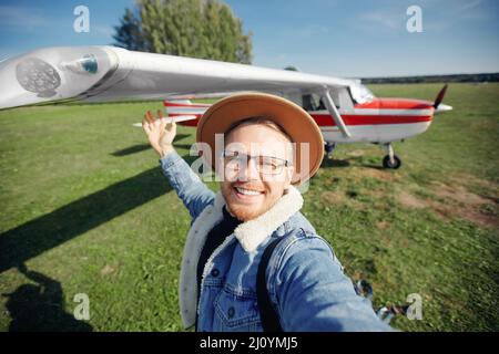 Selfie photo happy man pilot in light aircraft cockpit, aviator headset ...