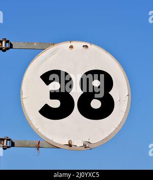 Number 38 in Blue: White Numerals on Metal Plate Around the Blurry ...