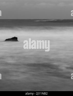 A beautiful grayscale of sea waves crashing on rocks Stock Photo - Alamy