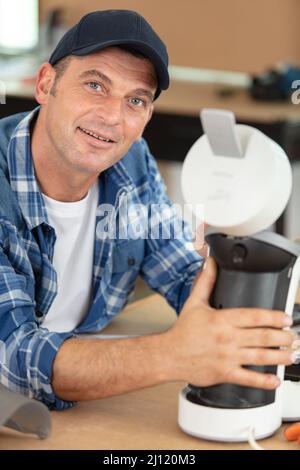 happy man repairing broken coffee machine Stock Photo - Alamy