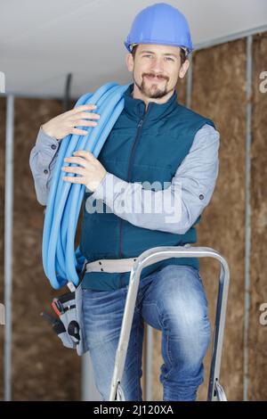 plumber standing on ladder and working with pipes in bathroom Stock ...