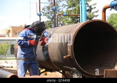 Male welder works. Welding joint of large diameter pipe. High pressure ...