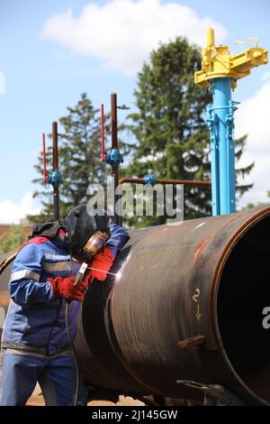 Male welder works. Welding joint of large diameter pipe. High pressure ...