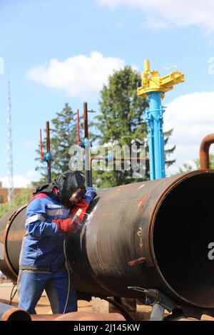 Male welder works. Welding joint of large diameter pipe. High pressure ...