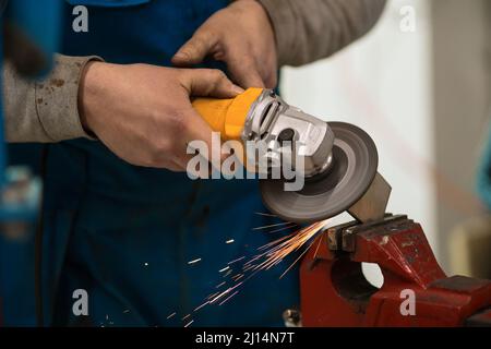 Technician worker cutting metal with many sharp sparks. Using ...