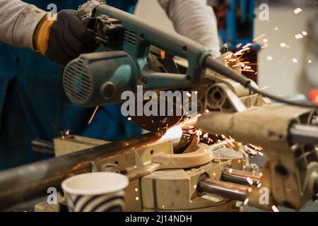 Technician worker cutting metal with many sharp sparks. Using ...